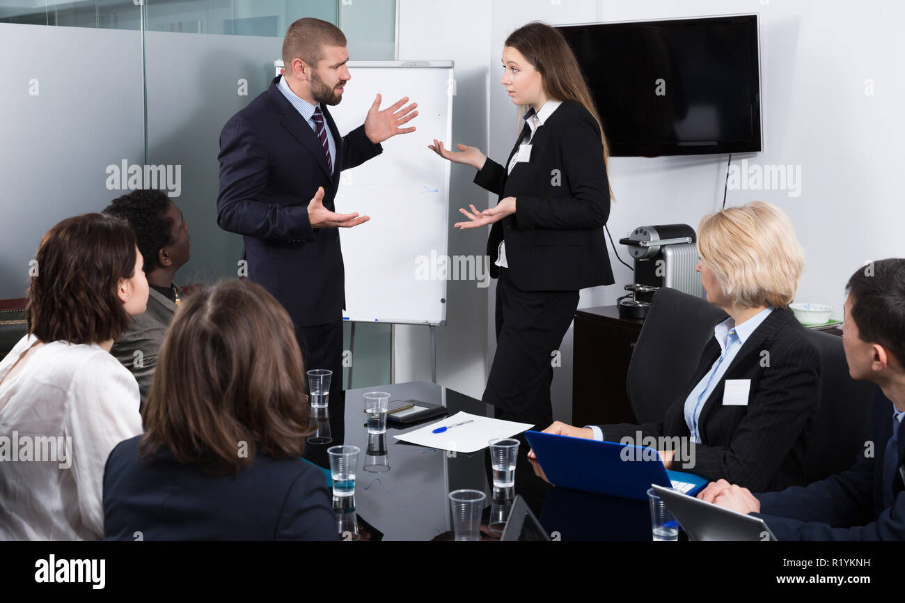 Businessman feeling angry to young female coworker in office, pointing ...
