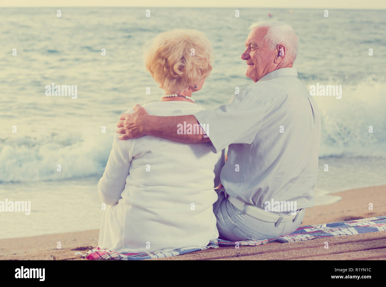 Portrait of mature female and male back hugging on the beach Stock ...