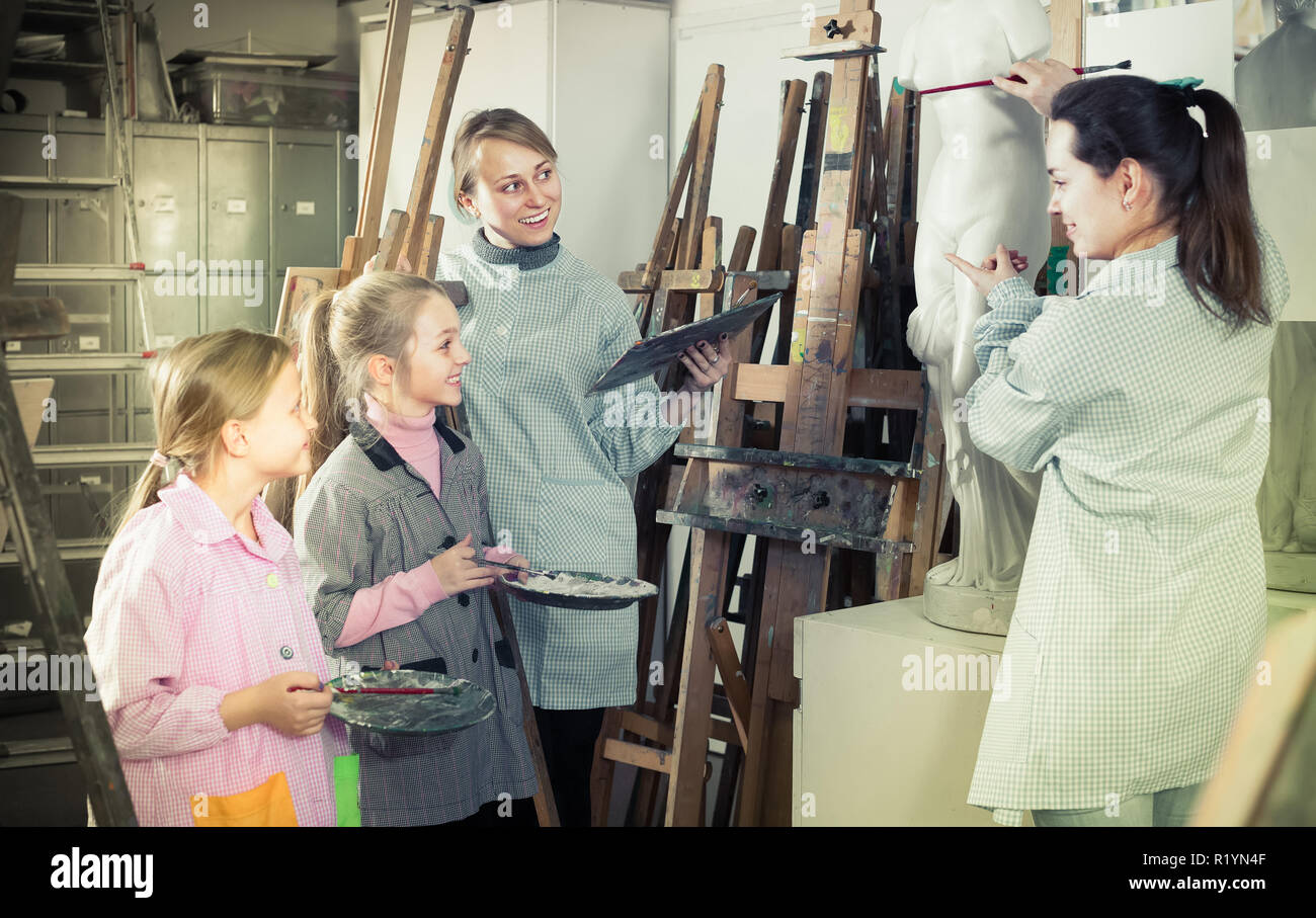 Skillful woman teacher demonstrating useful painting tips during class ...