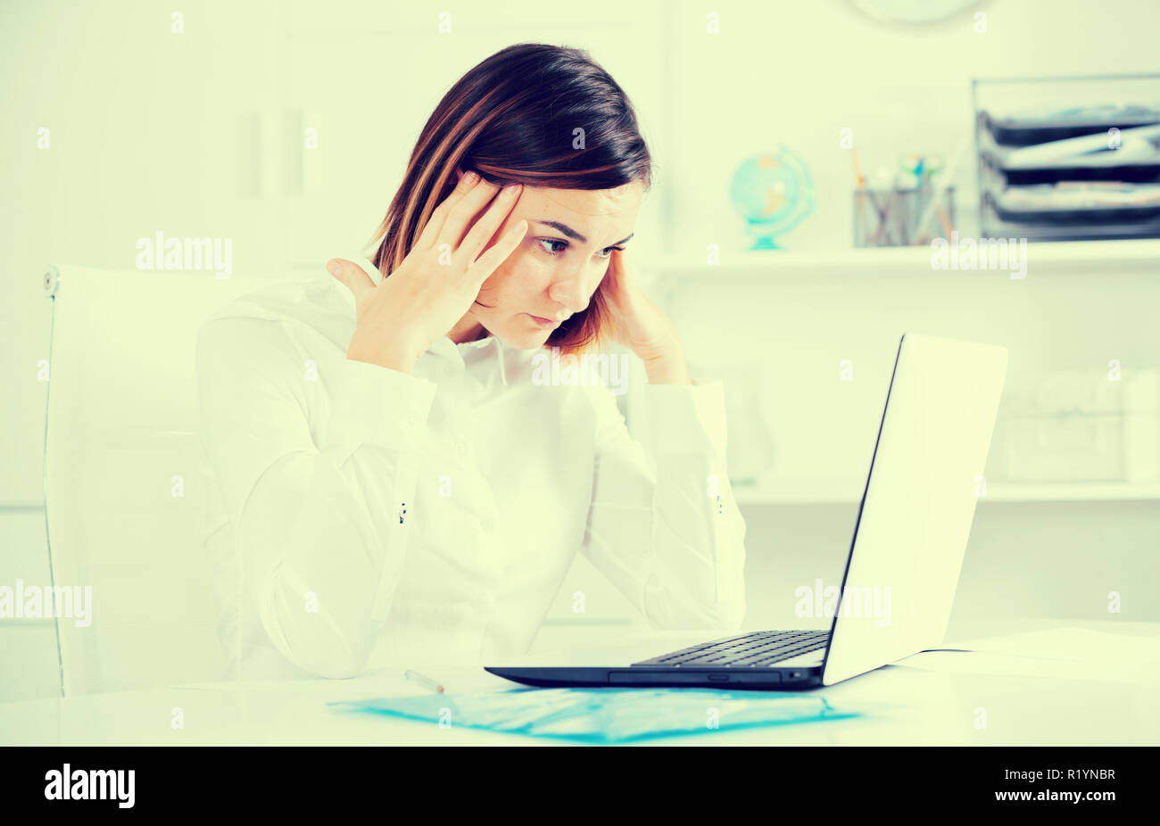 Young female worker having problem in project in office Stock Photo - Alamy