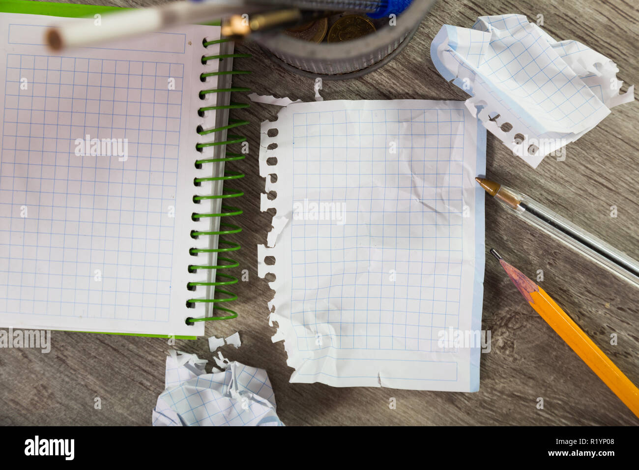 Torn crumpled notebook sheet in cage surrounded by stationery Stock ...