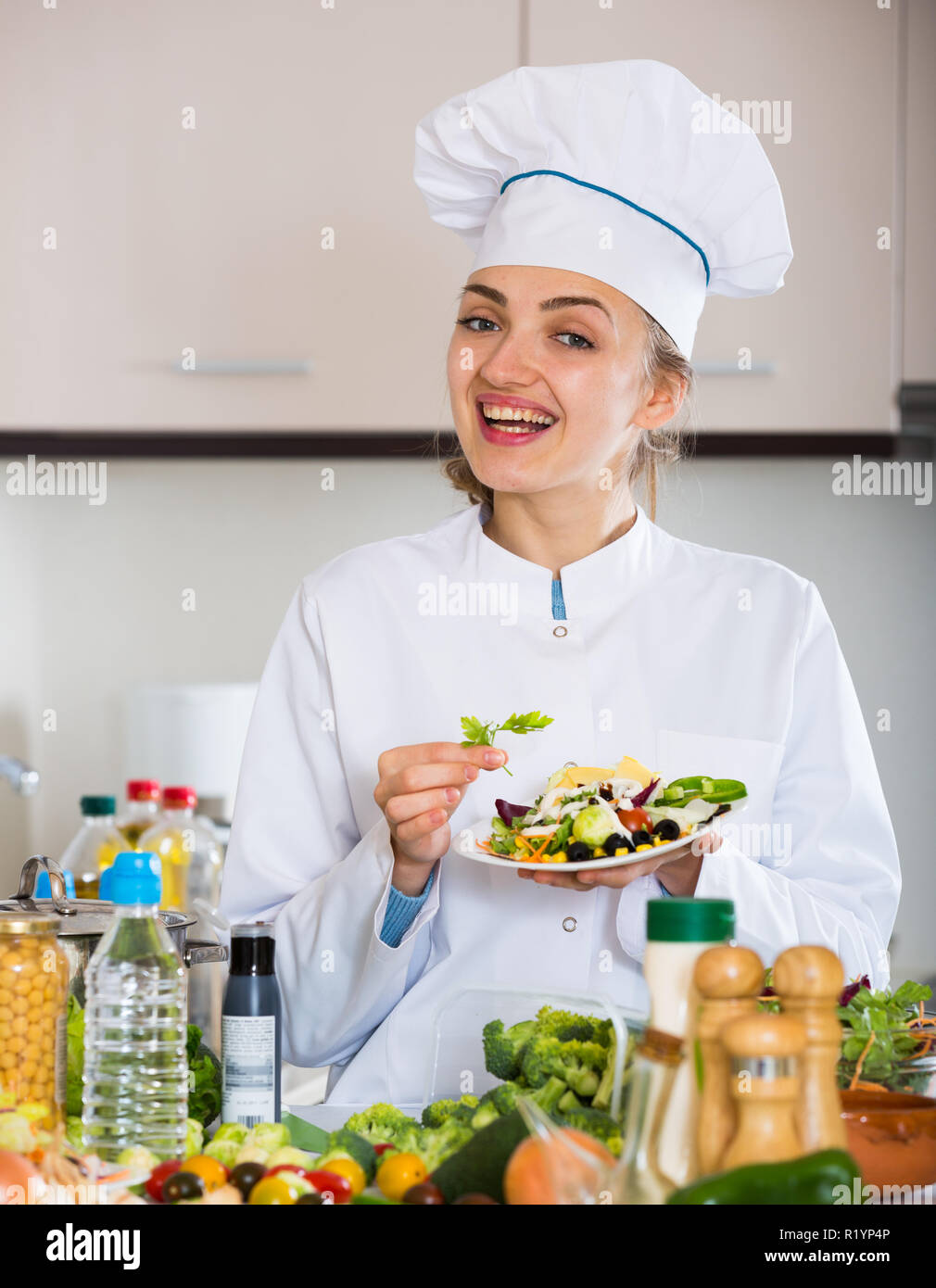 Happy female cook with vegetables salad in commercial kitchen Stock ...