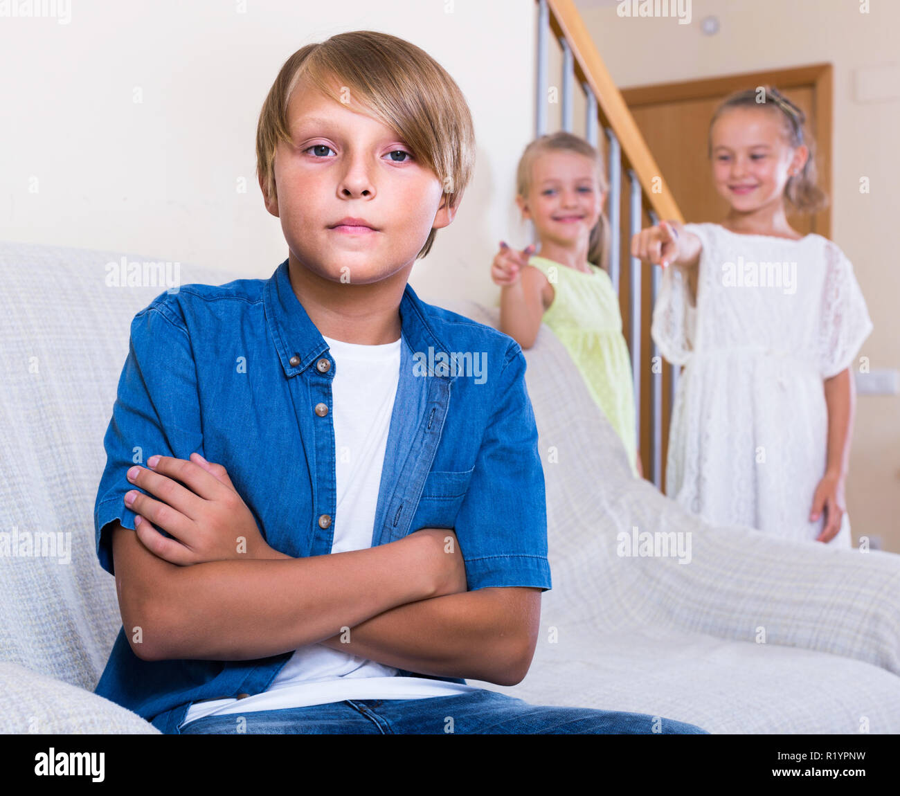 Two little girls talking and sulky european boy sitting separately at ...