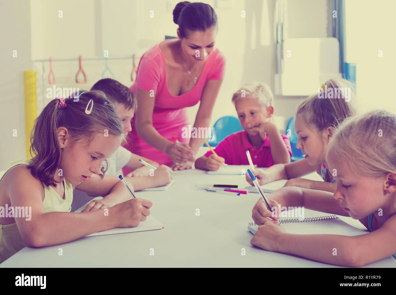 Glad diligent kids learning to write on lesson in elementary school ...