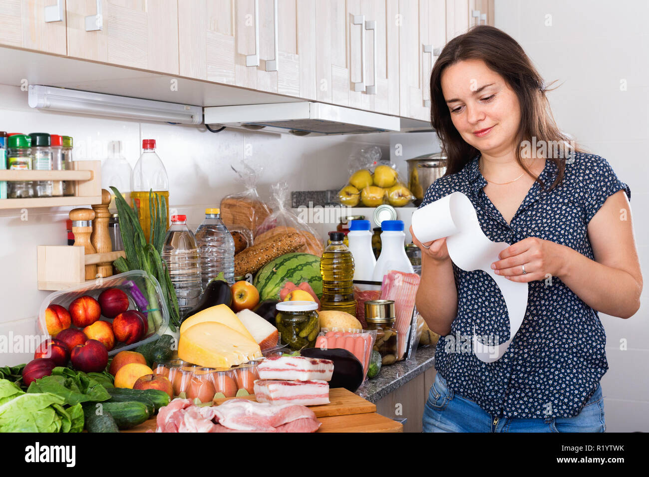 Glad cheerful positive woman is standing with check and satisfied of ...
