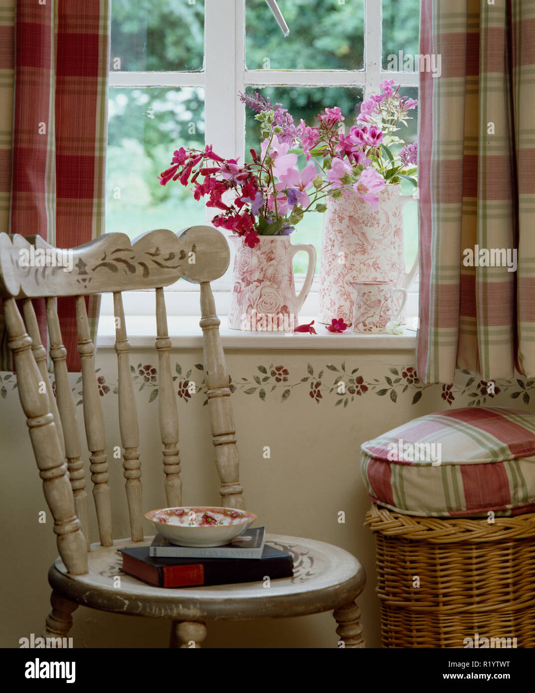 Stenciled chair and border beside windows with pink jugs Stock Photo ...