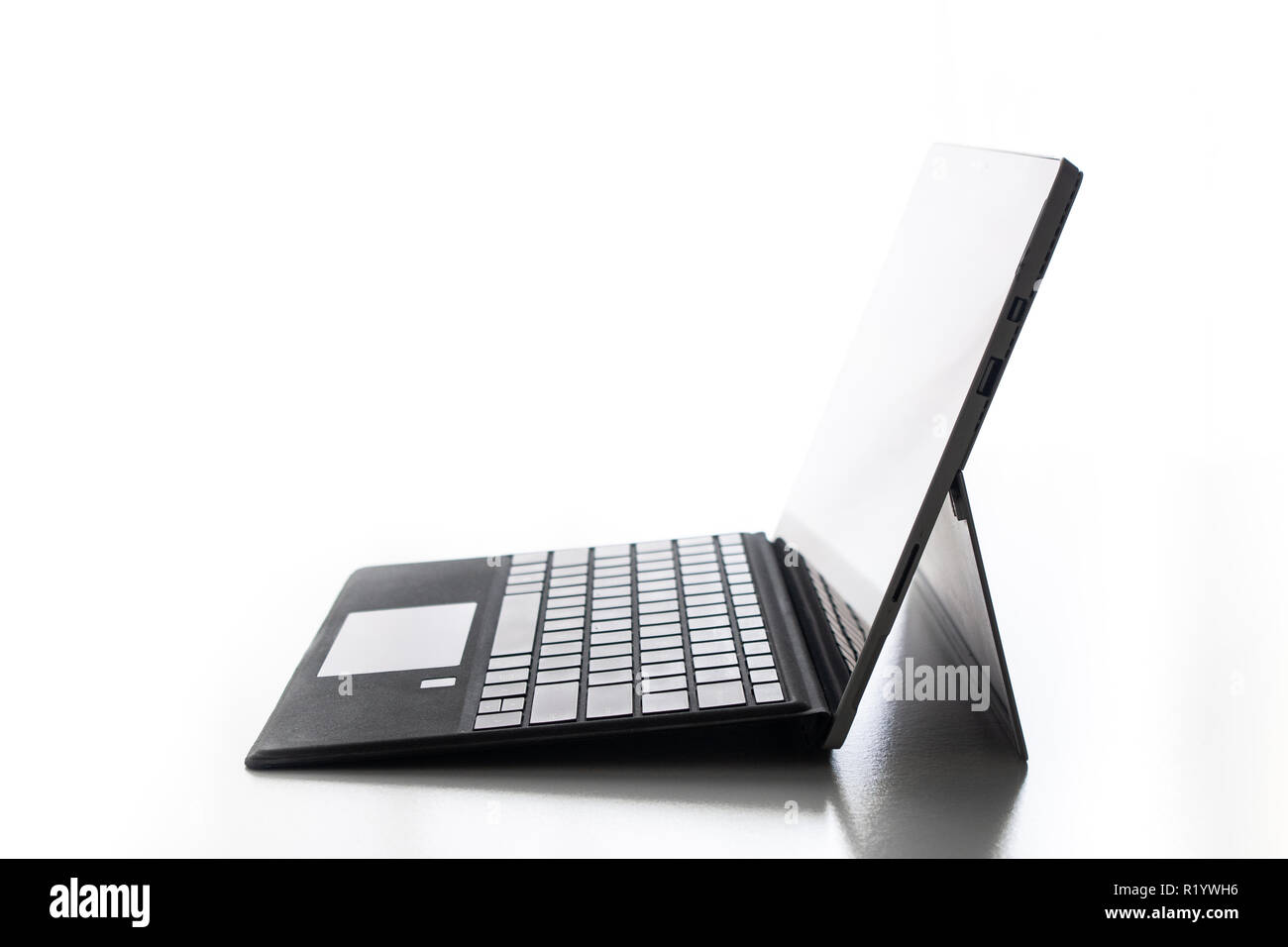 Compact laptop tablet opened exposed keys pure white background grey ...