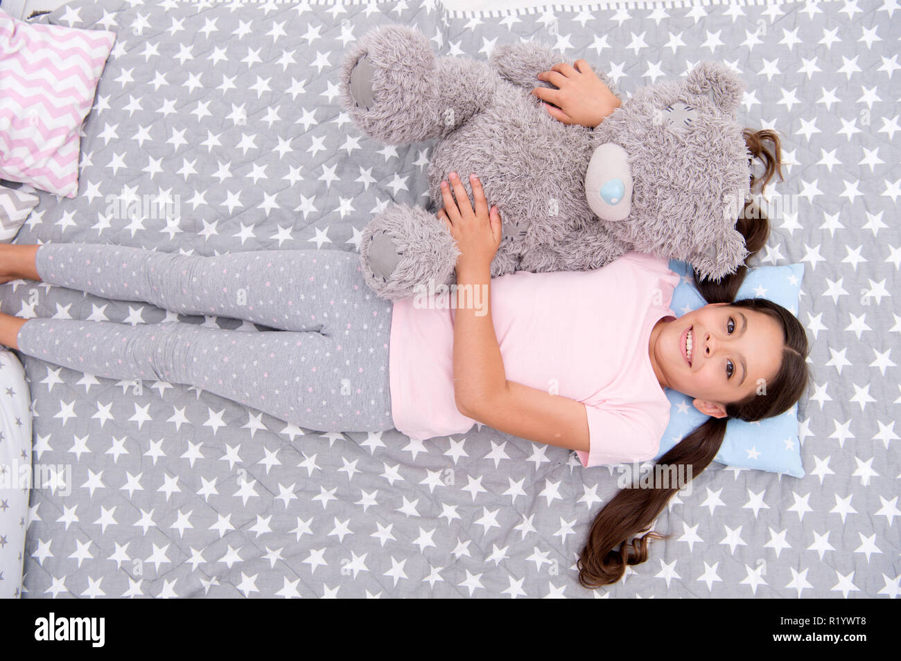 Relax concept. Little girl relax in bed. Cute child relax with teddy ...