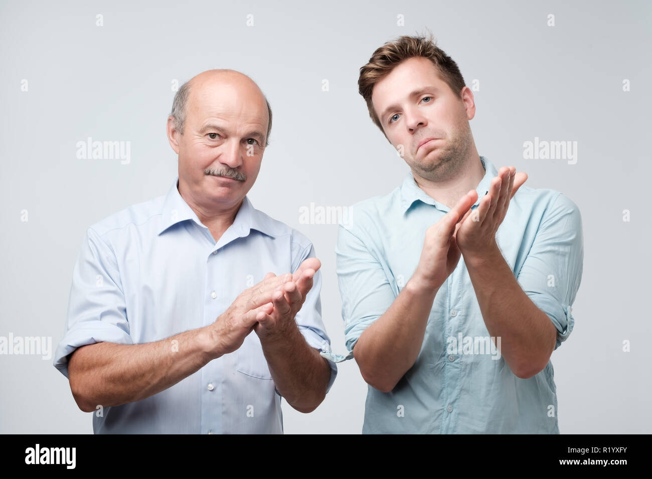Two handsome mature men smiling and clapping hands. Son and father ...