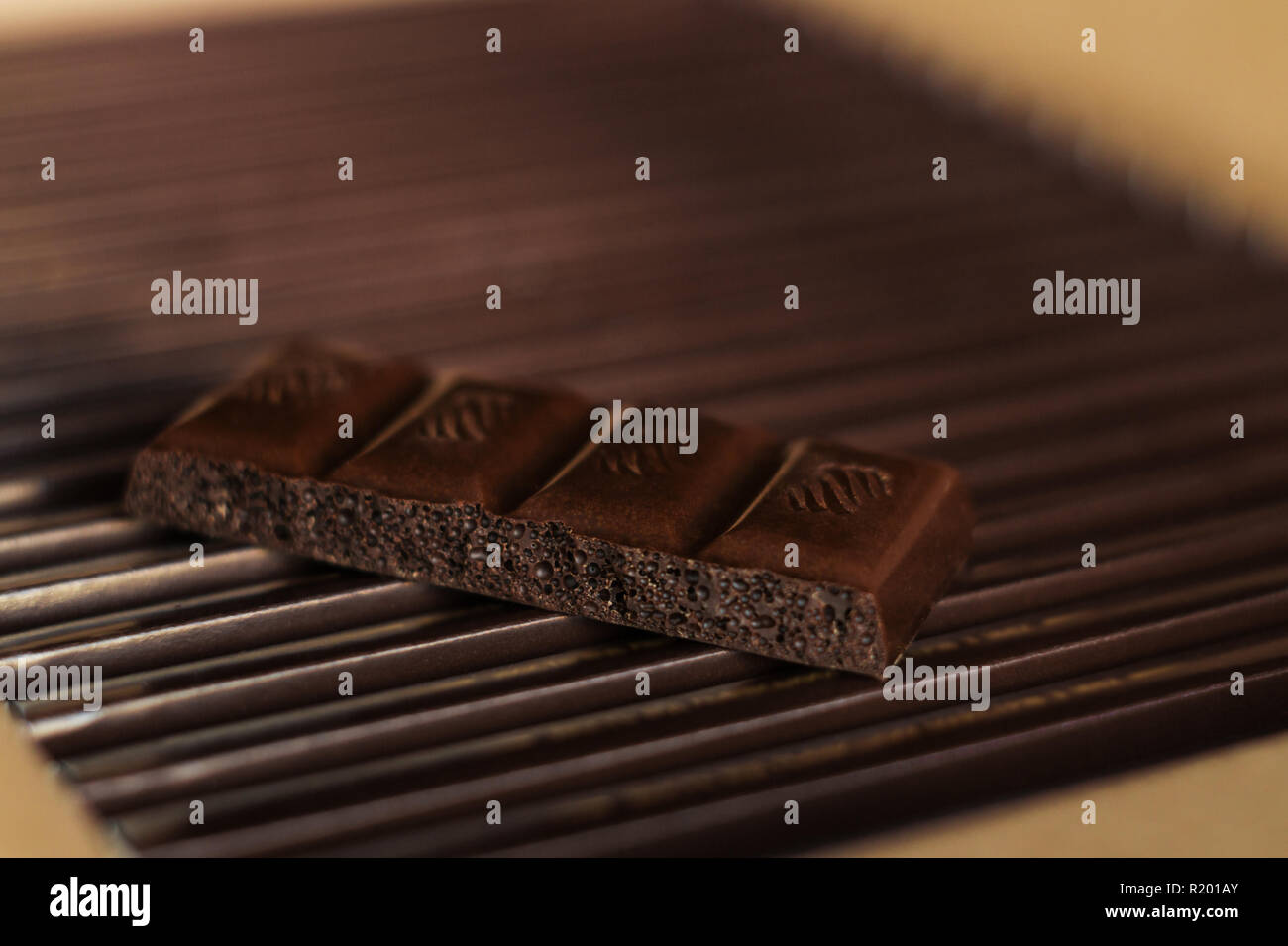 Tiles of dark chocolate on a cardboard box packed with chocolate. Close ...