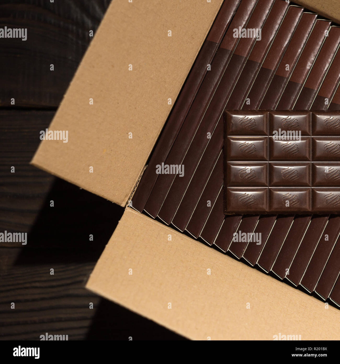 Tiles of dark chocolate on a cardboard box packed with chocolate. Top ...