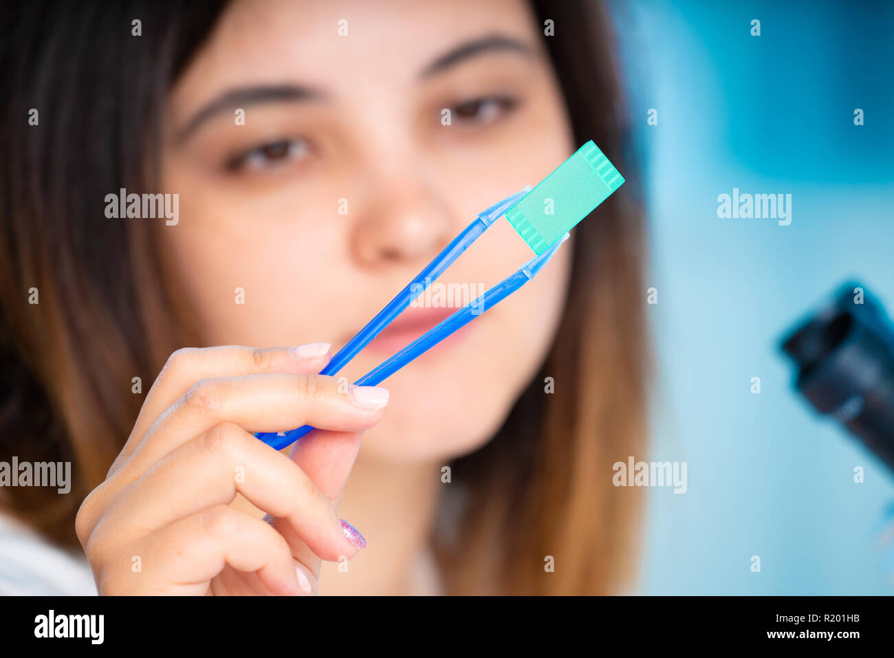 technician girl with microfluidic device LOC in microbiological lab ...