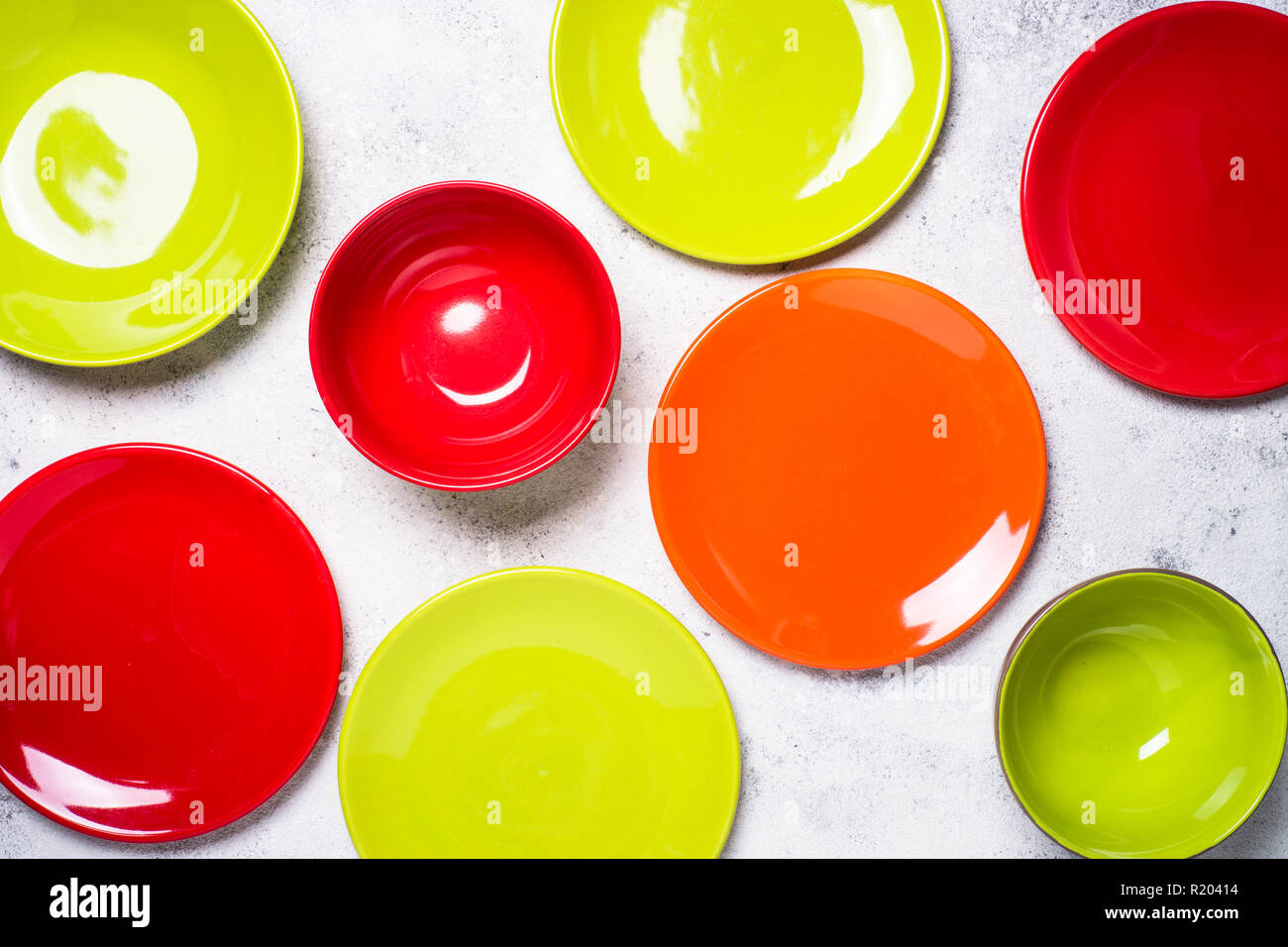 Colored dinnerware - red and green plates on light stone table Stock ...