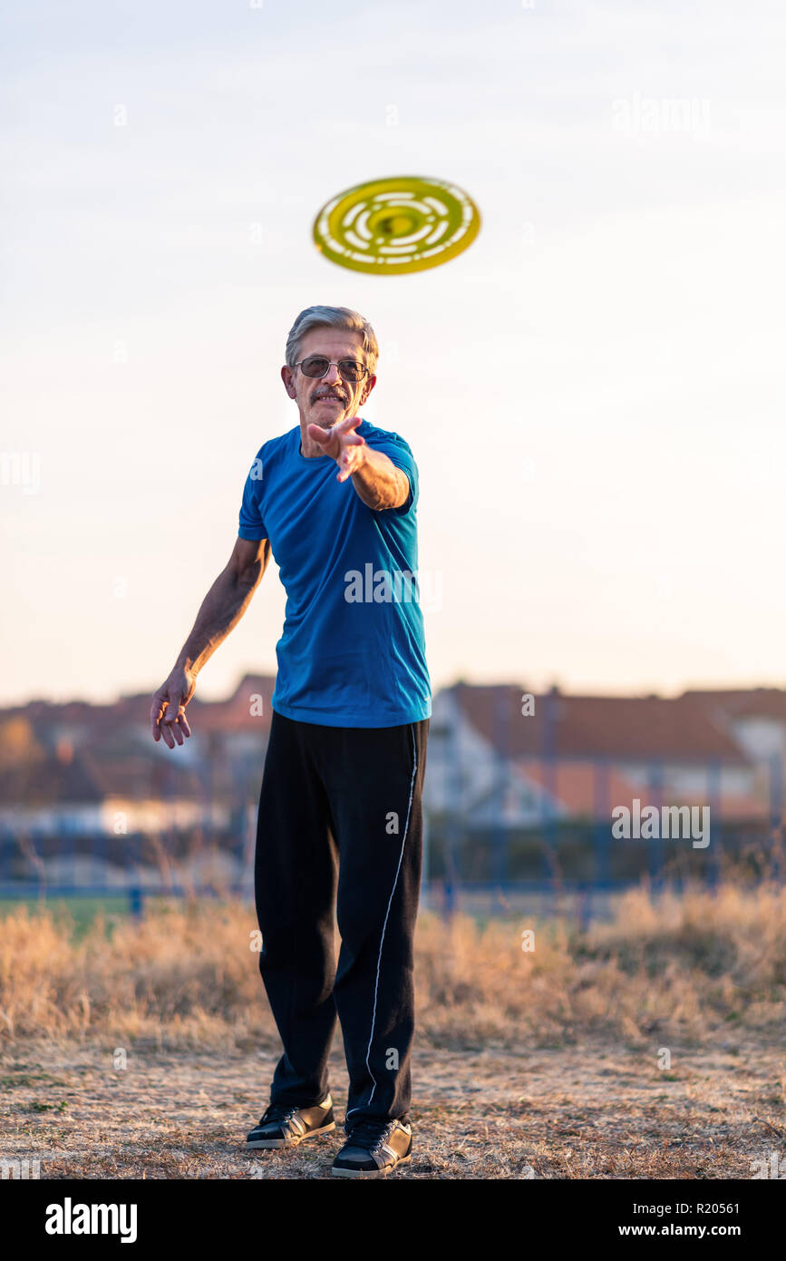 Senior man playing frisbee in the park outdoors Stock Photo - Alamy