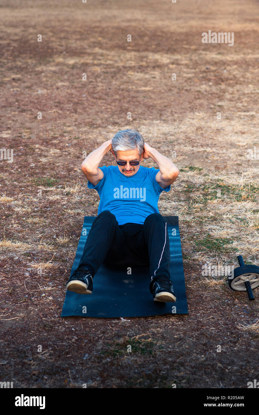 Senior man doing crunches for a outdoors workout Stock Photo - Alamy