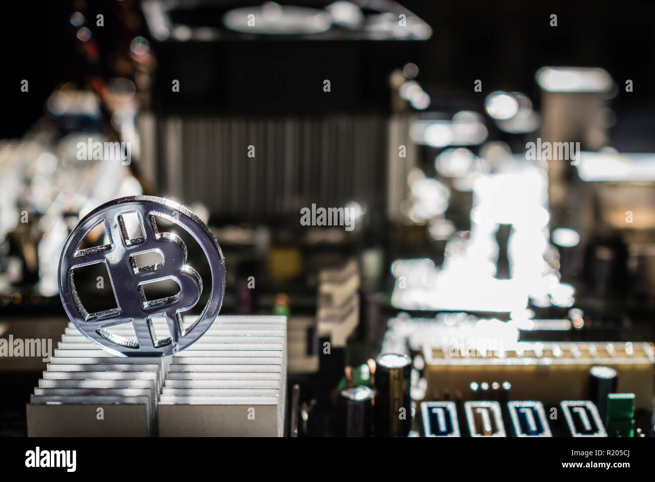 Plastic clear bit coin with motherboard and electronic background and ...