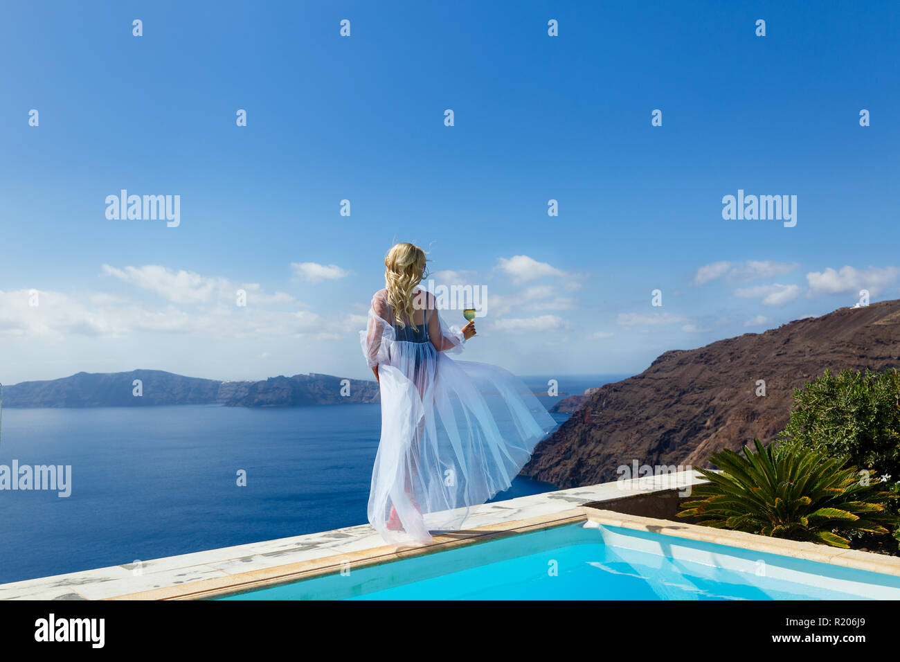 Beautiful woman on the edge of the pool standing over the sea, Greece ...