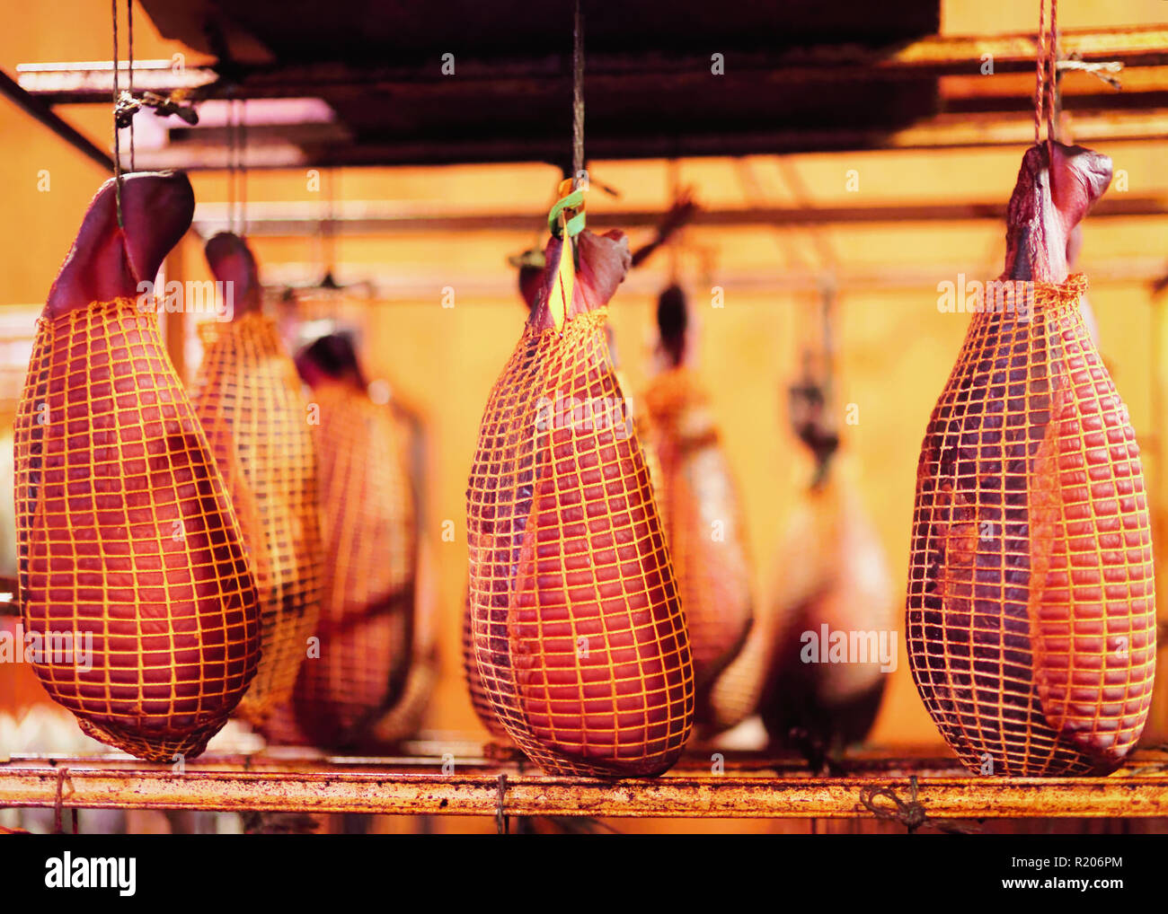 Hanging legs of traditional cured french meat at ripening cellar in ...