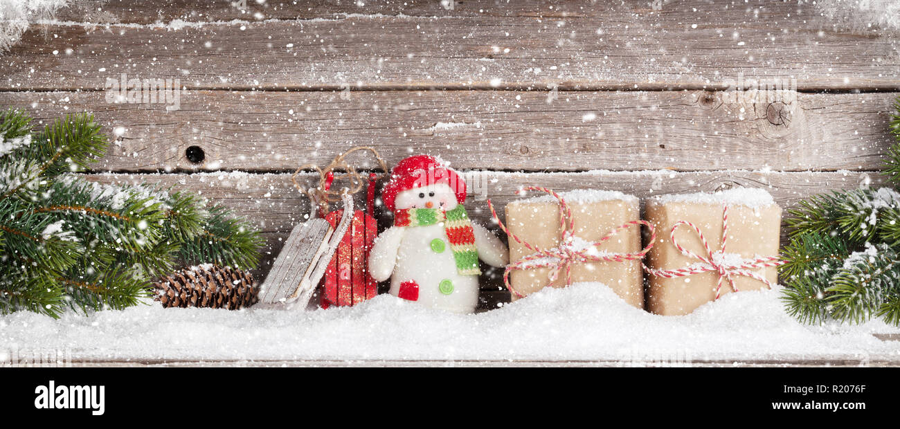 Christmas gift boxes, snowman toy and xmas fir tree branch. View with ...