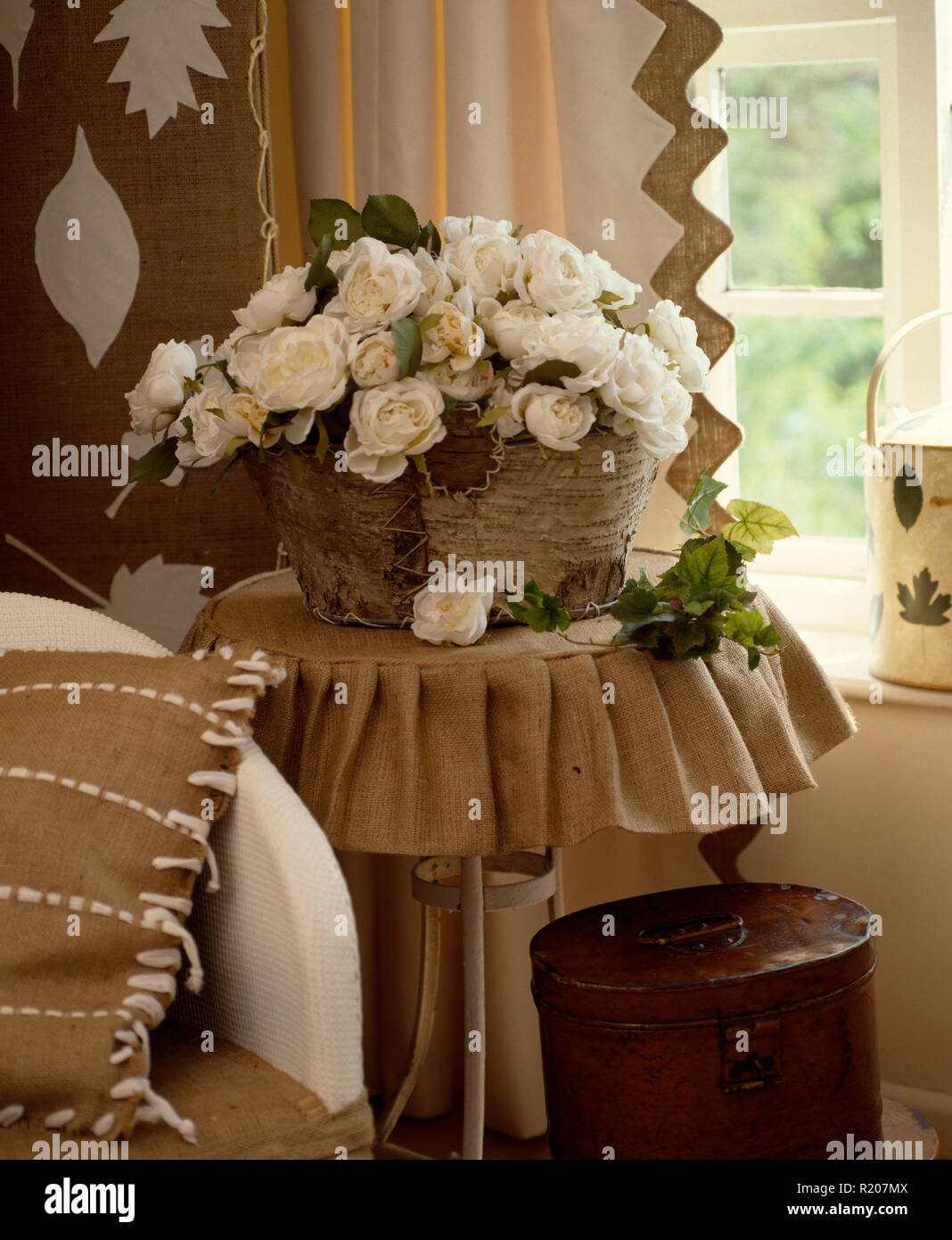 Basket of white roses on table with pleated heavy linen cloth Stock ...