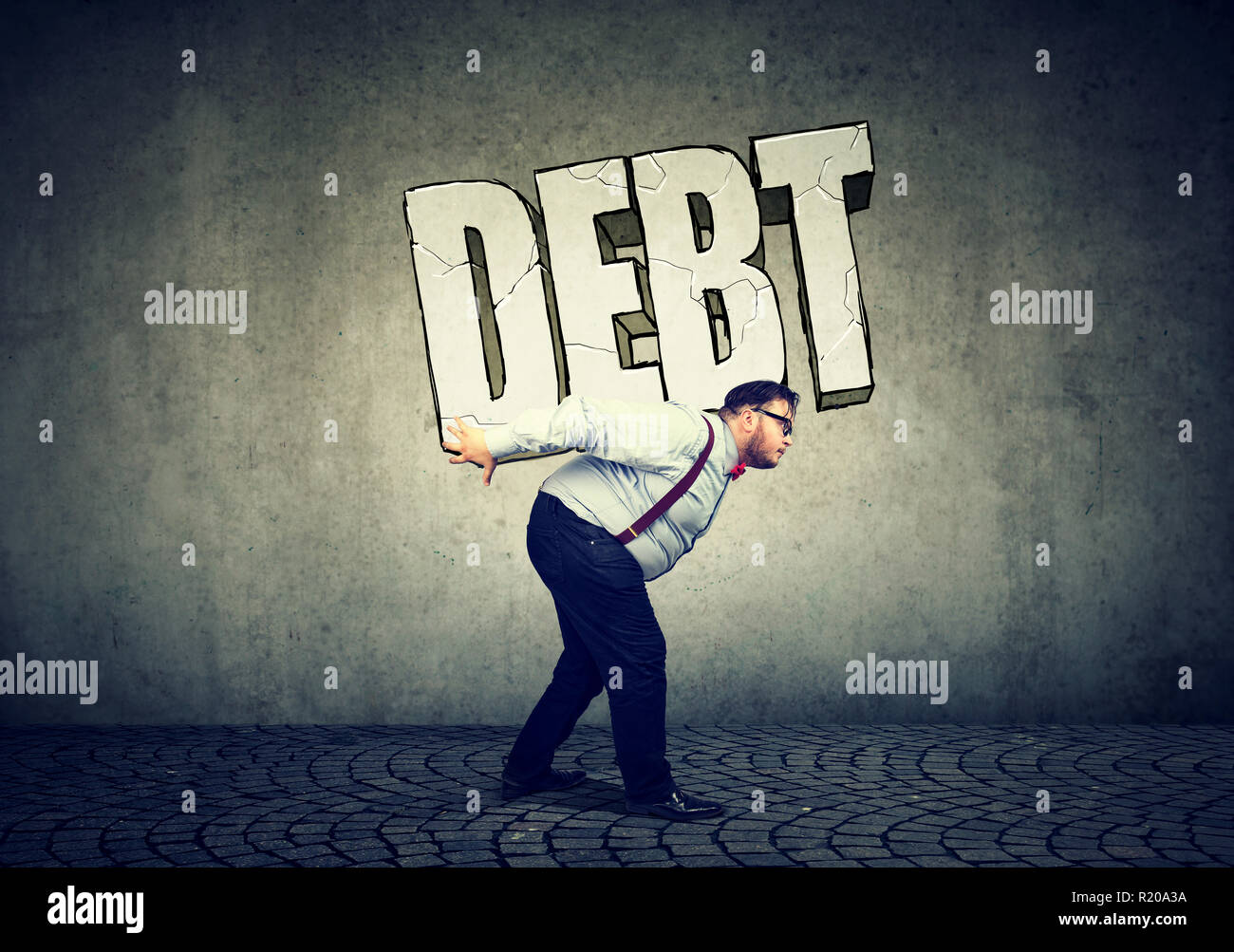 Businessman with huge DEBT on his back as a symbol of burden of owing a ...