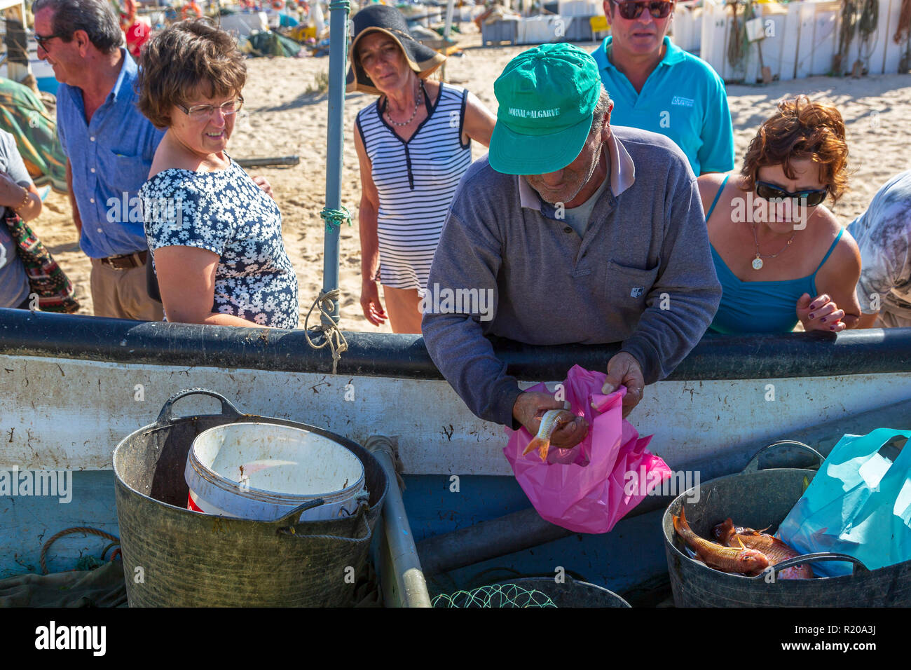 Local fisherman selling freshly caught fish from his small fishing boat ...