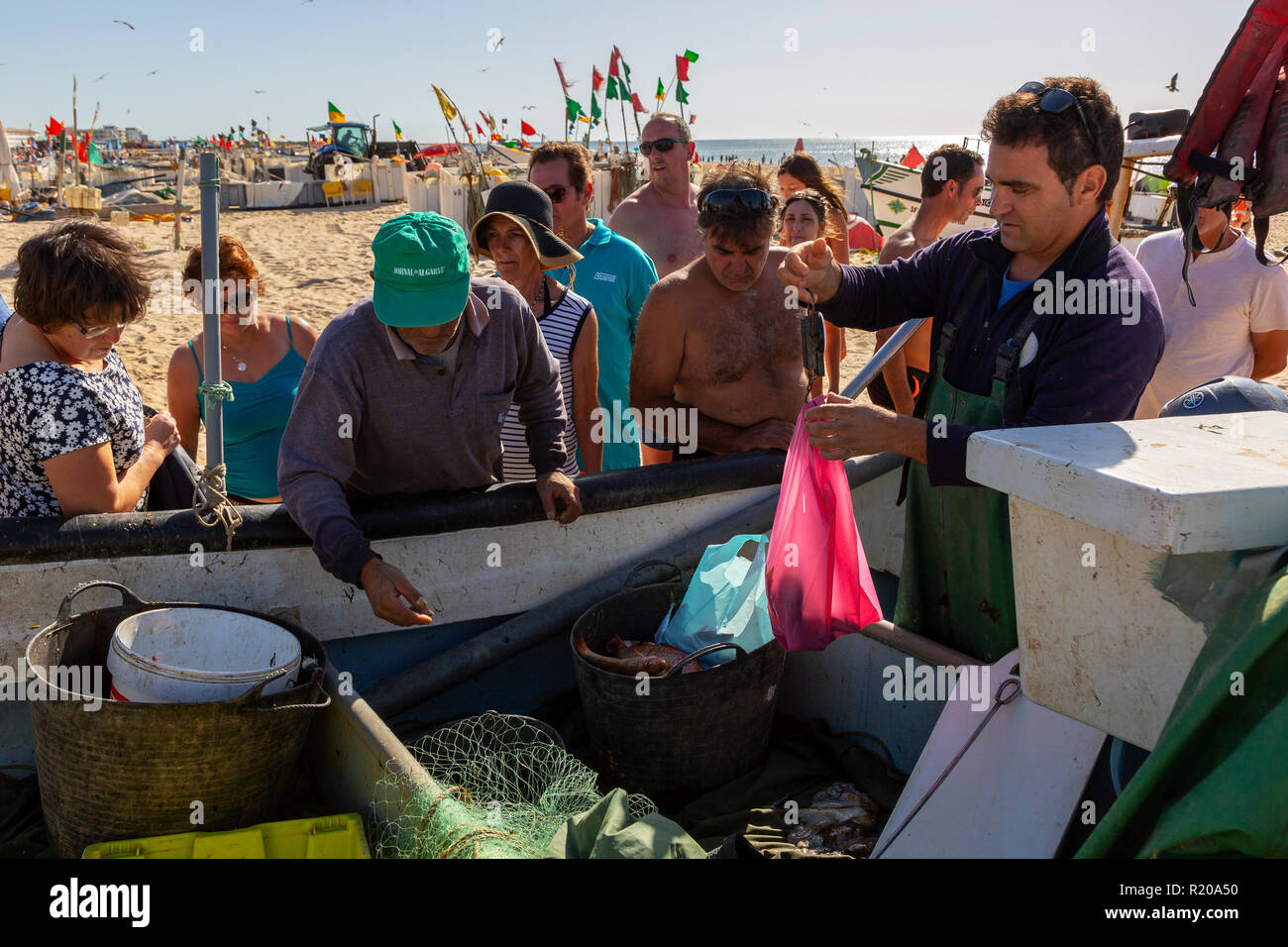 Local fisherman selling freshly caught fish from his small fishing boat ...