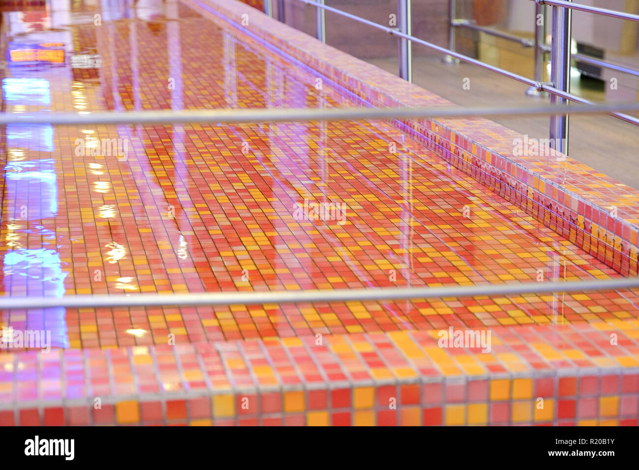 water in the pool with red-orange decorative tiles Stock Photo - Alamy