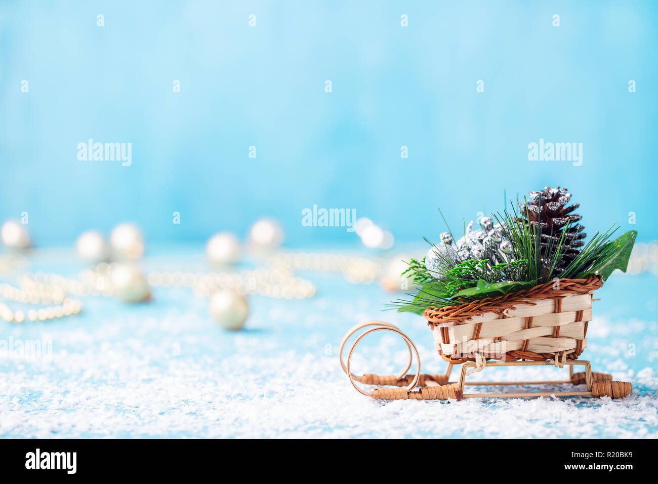 Christmas sledge with snow and tree decoration. Blue background. Copy ...