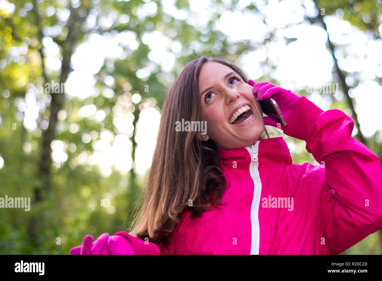 Young caucasian brunette girl talking on the phone in very happy and ...