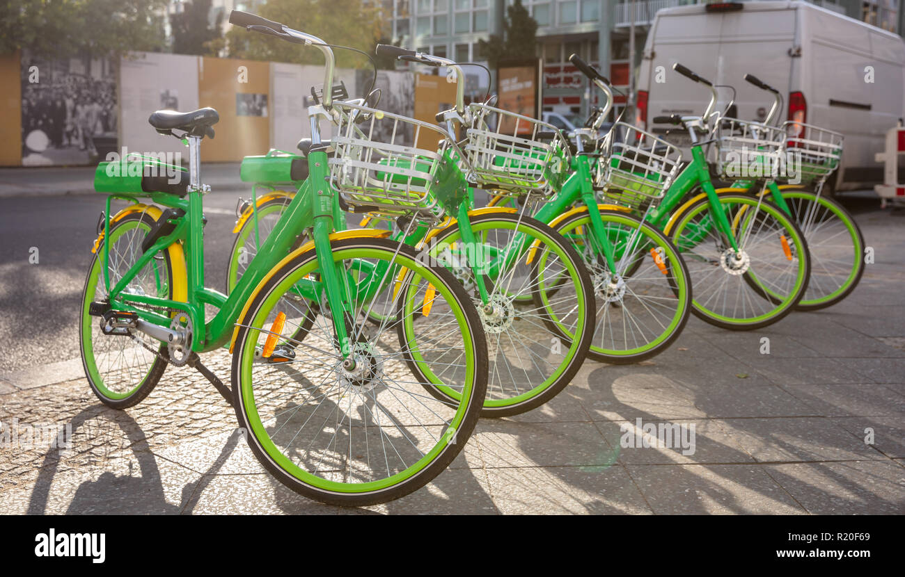 Green rental bicycles with baskets parked on a cobblestone street ...