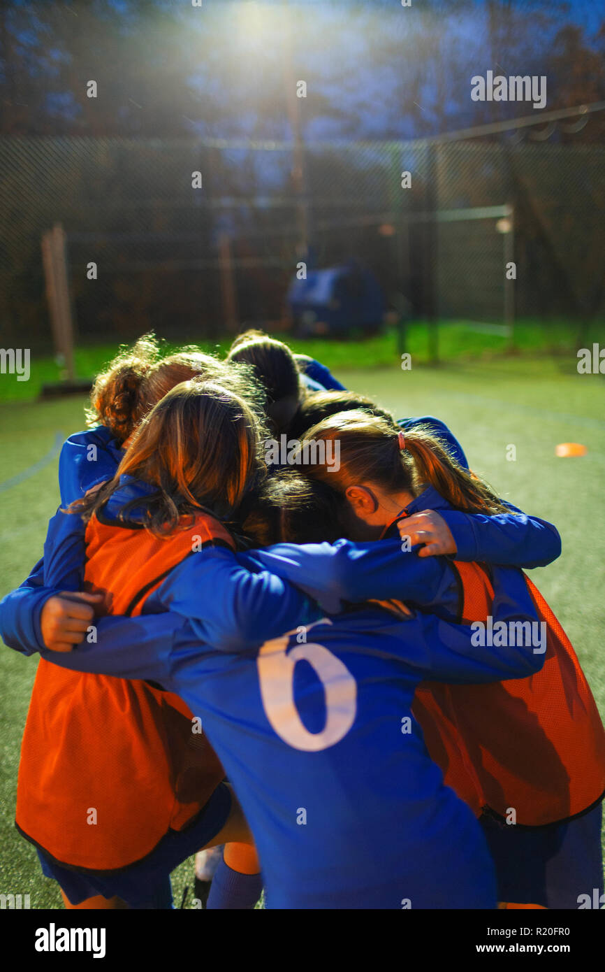 Girls soccer team in huddle on field at night Stock Photo - Alamy