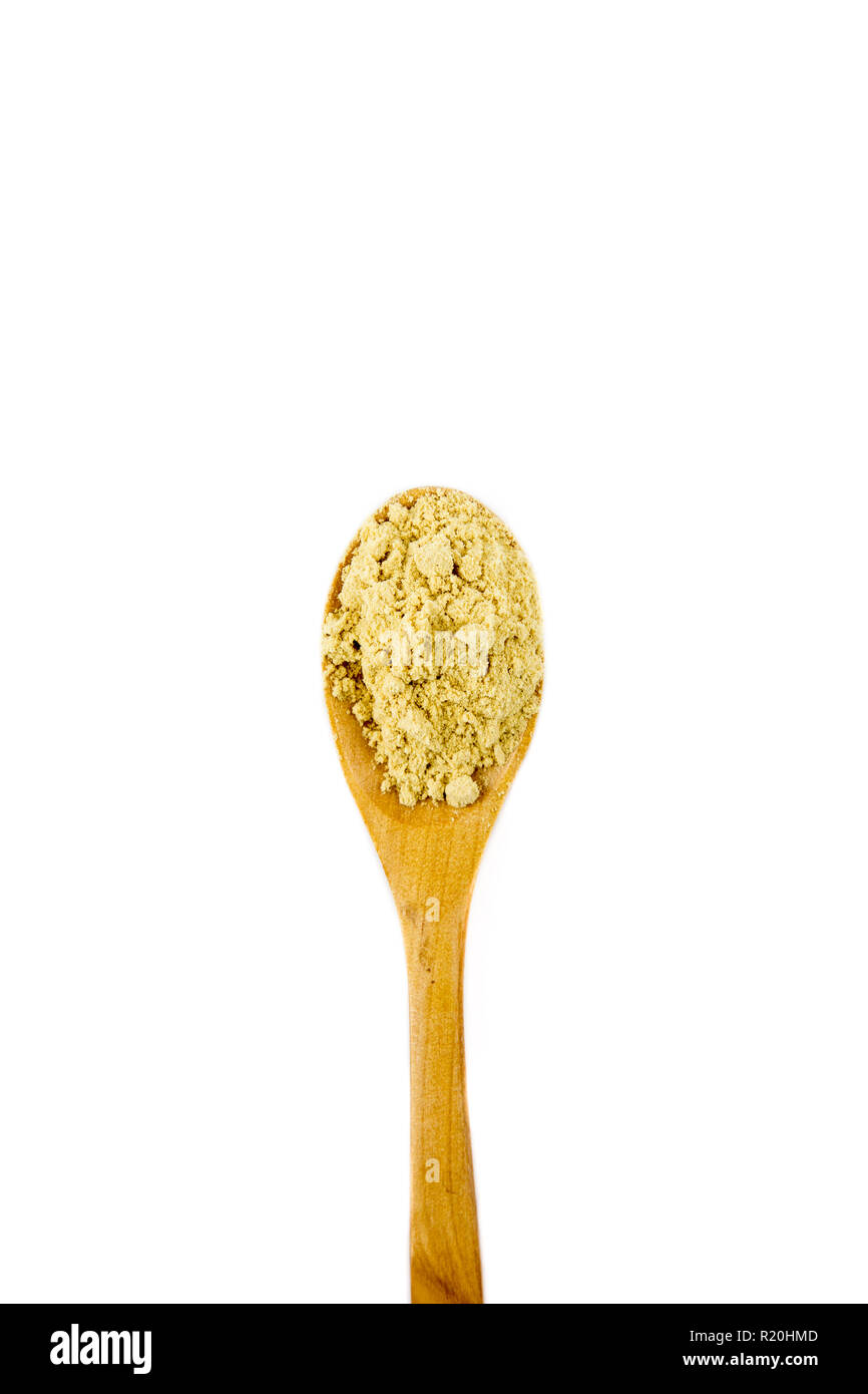 Flat lay view of dried yellow mustard powder on wooden spoon, isolated ...