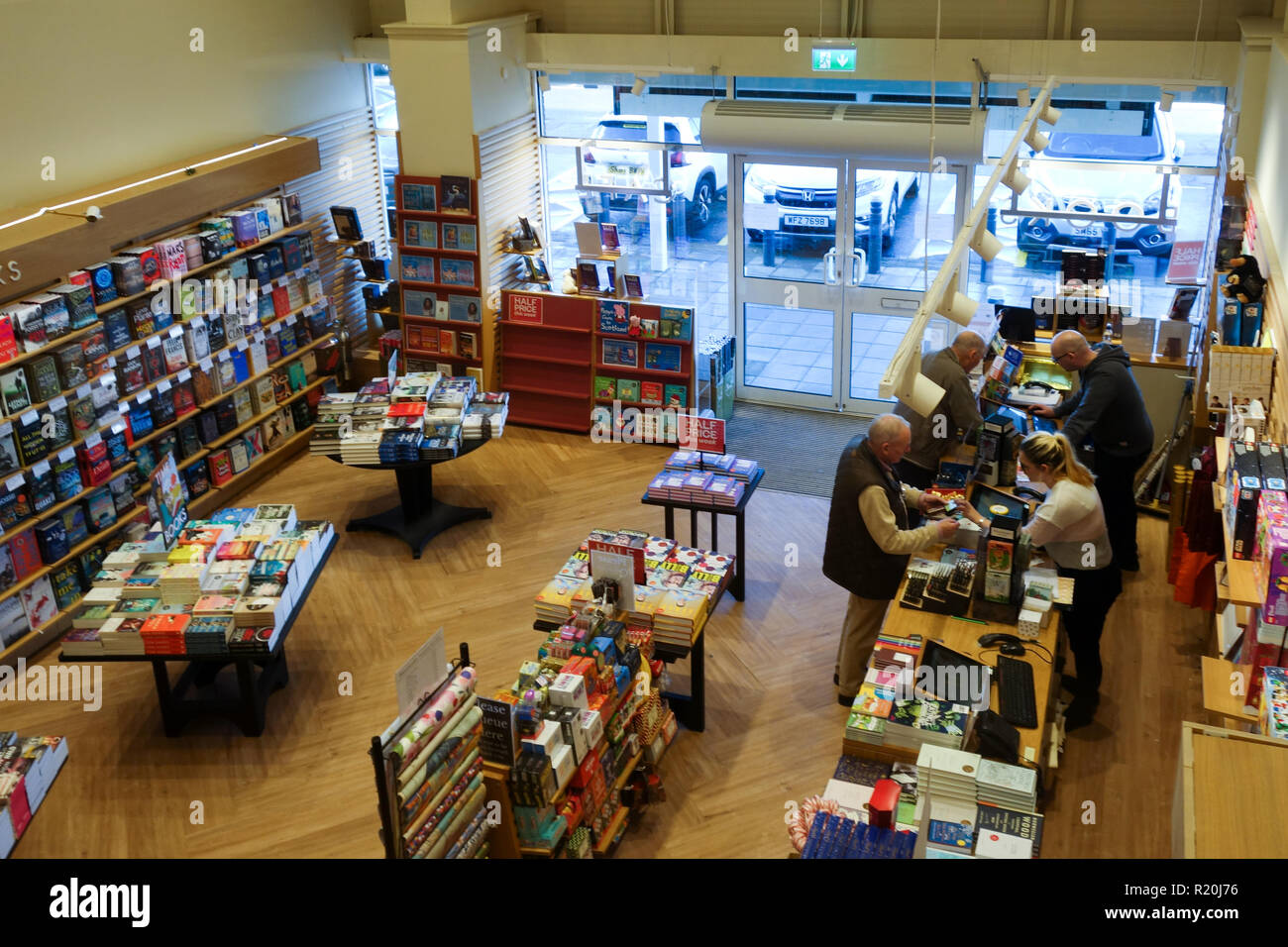 Customers and staff at counter in bookshop in shopping mall Stock Photo ...