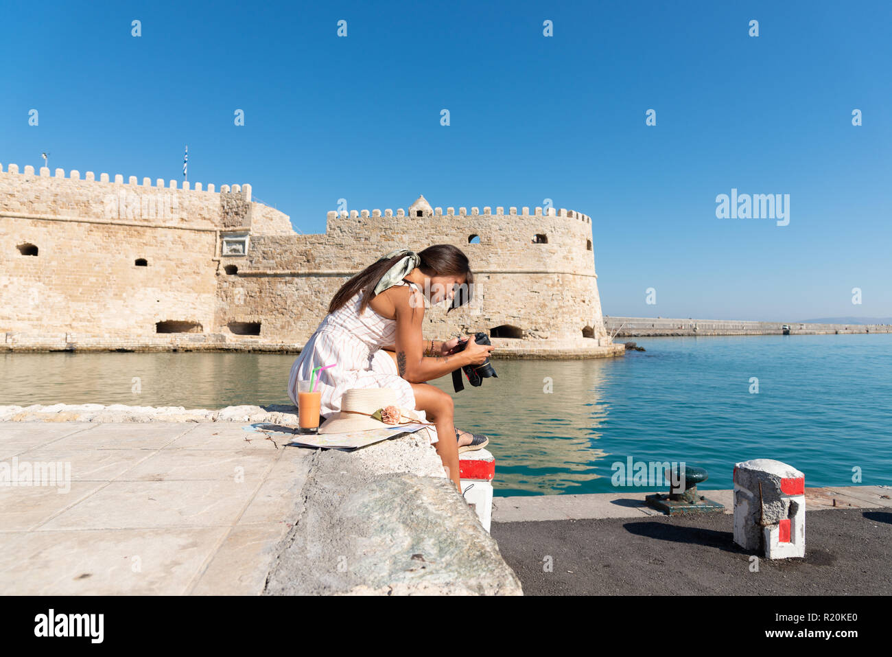 Happy tourist woman relaxing at the Venetian port of Heraklion. Lovely ...