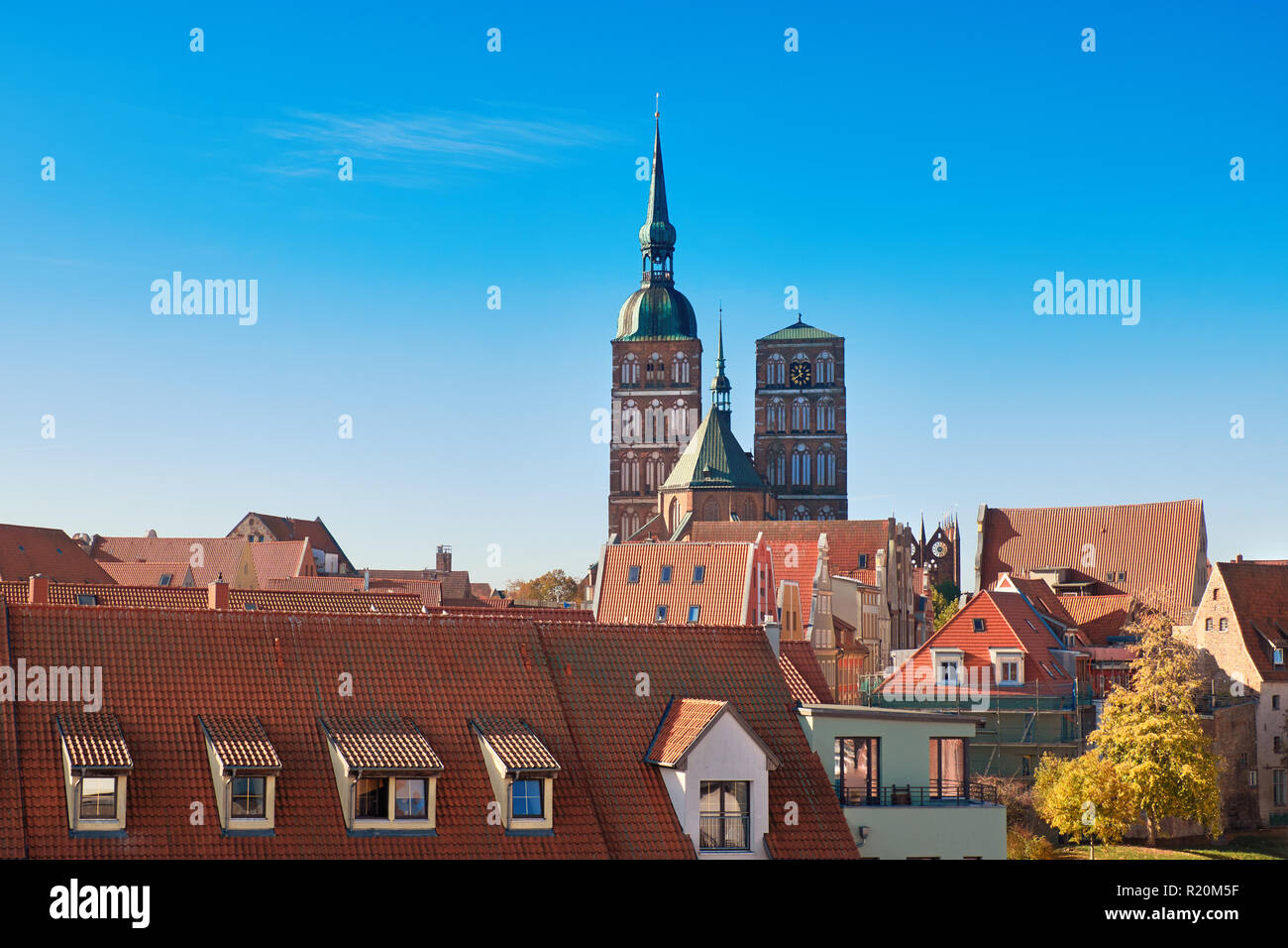 Orange tiled roofs of Stralsund with towers of medieval parish Church ...