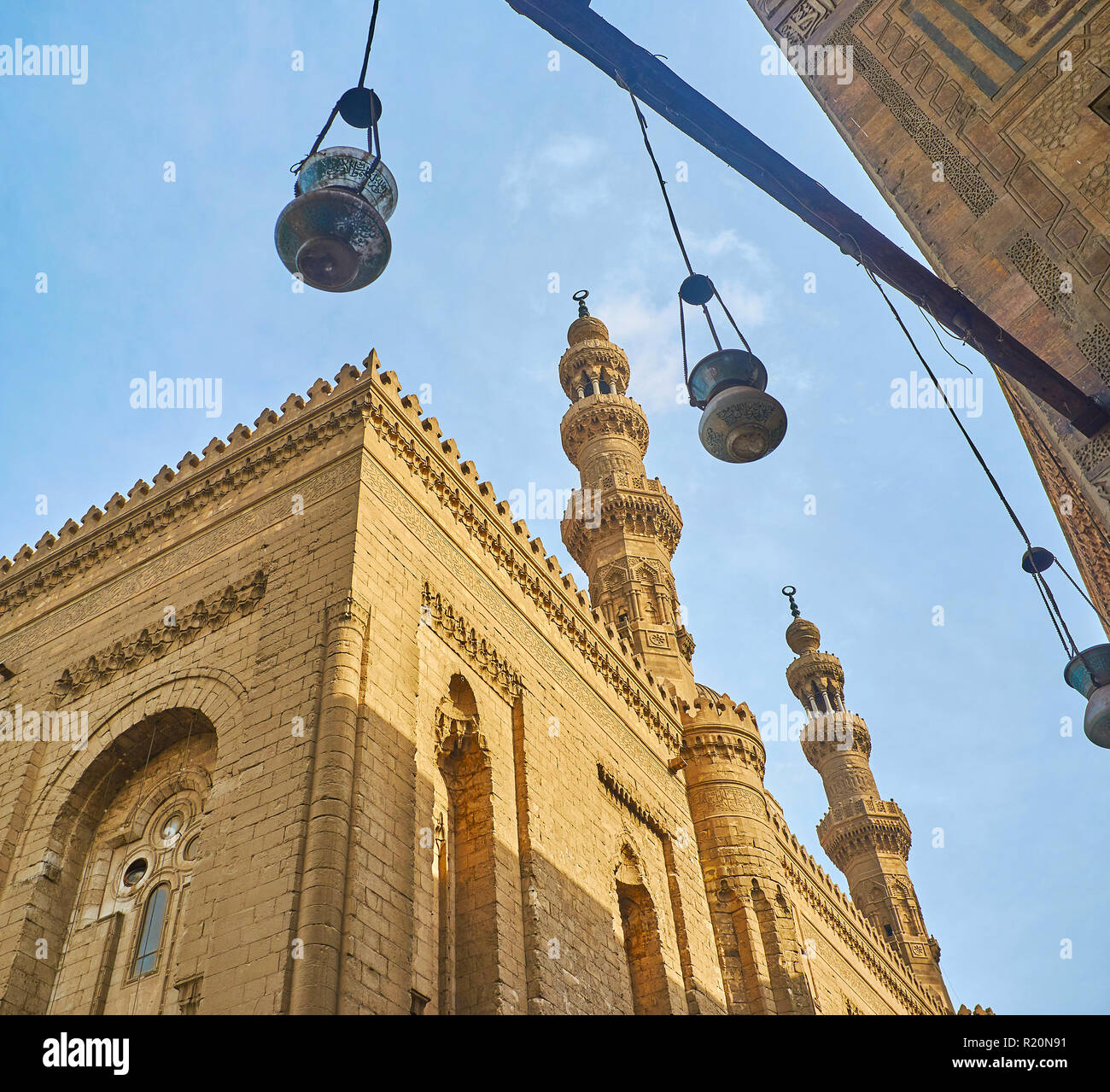 The carved stone minarets of Royal (Al Rifai') Mosque with oil lamps of Sultan Hassan Mosque ...