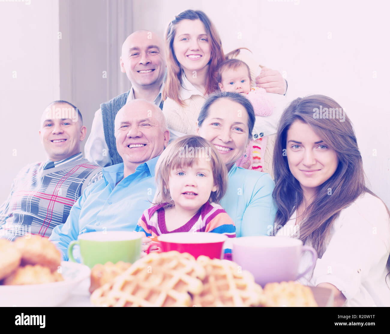 Portrait of happy three generations family posing together over tea at ...