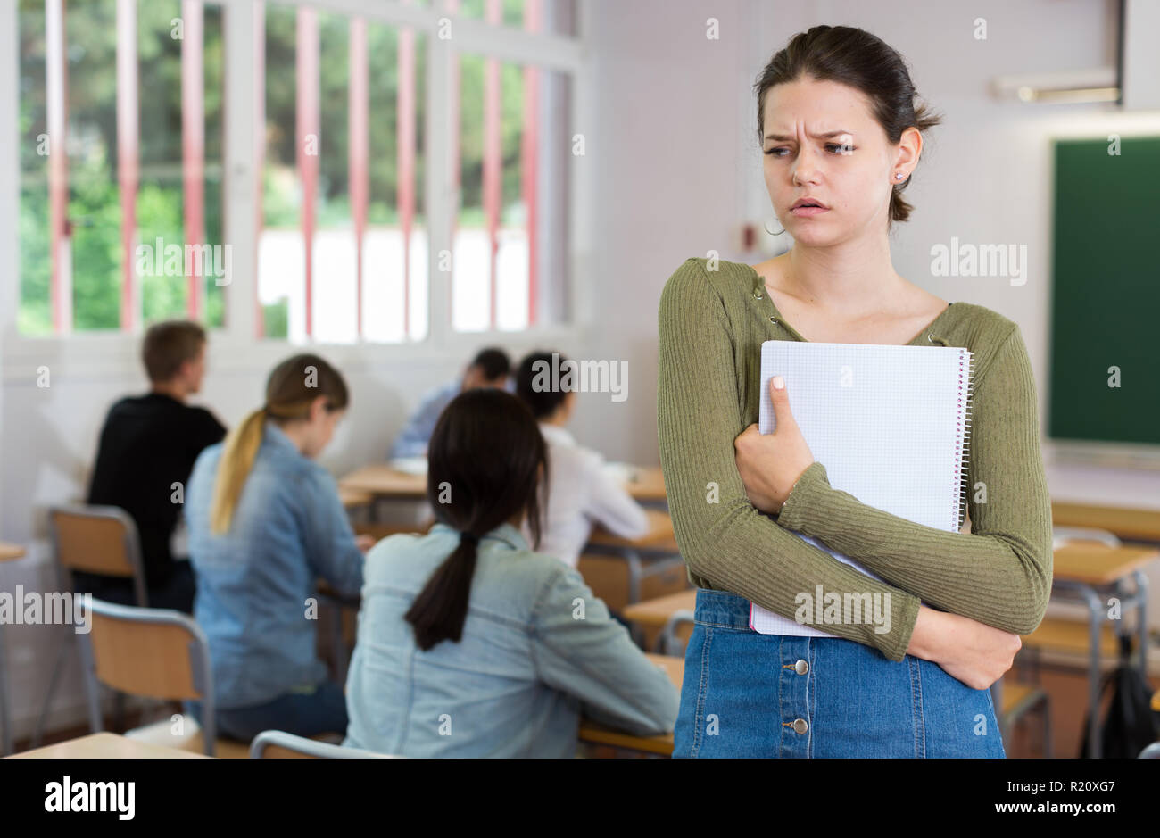 Portrait of sad schoolgirl who is standing dissatisfied after lecture ...