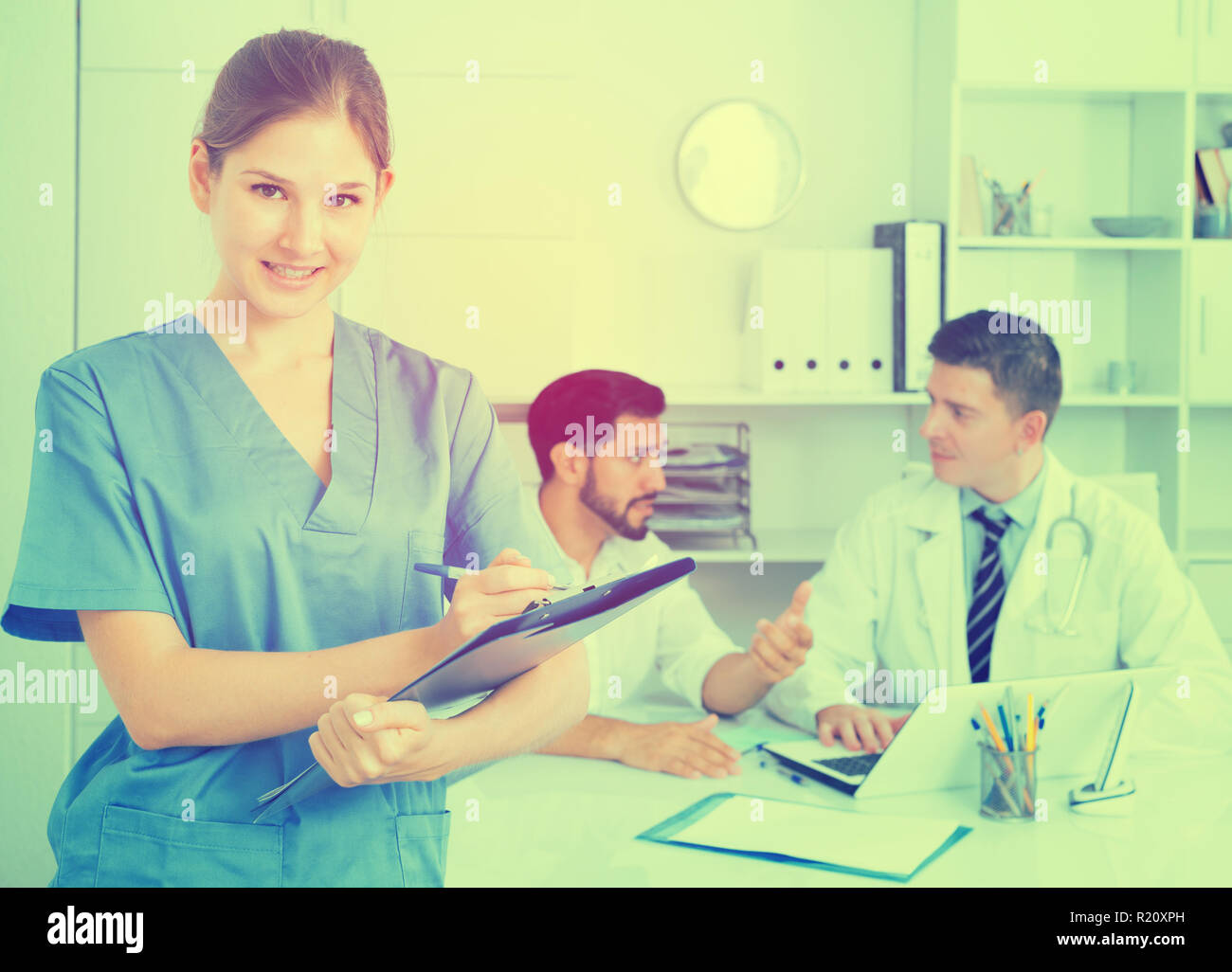 Smiling young female doctor writing notes on clipboard in clinic Stock ...