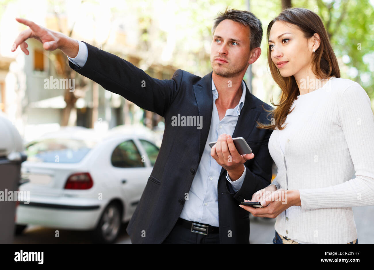 Couple is walking on city streets and watching something interesting ...