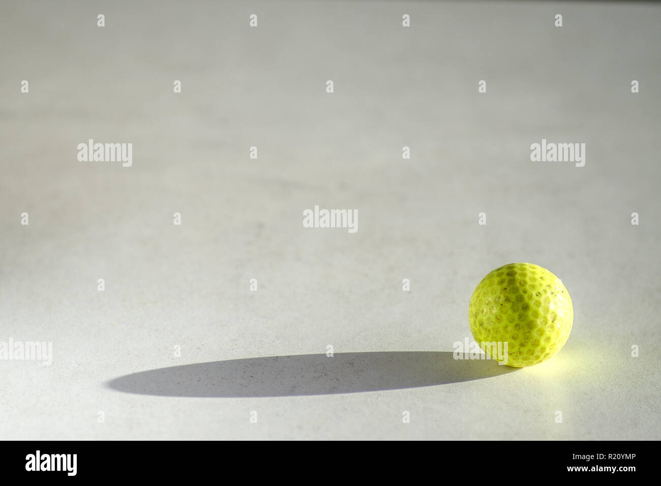 Old yellow golf ball on white backdrop Stock Photo - Alamy