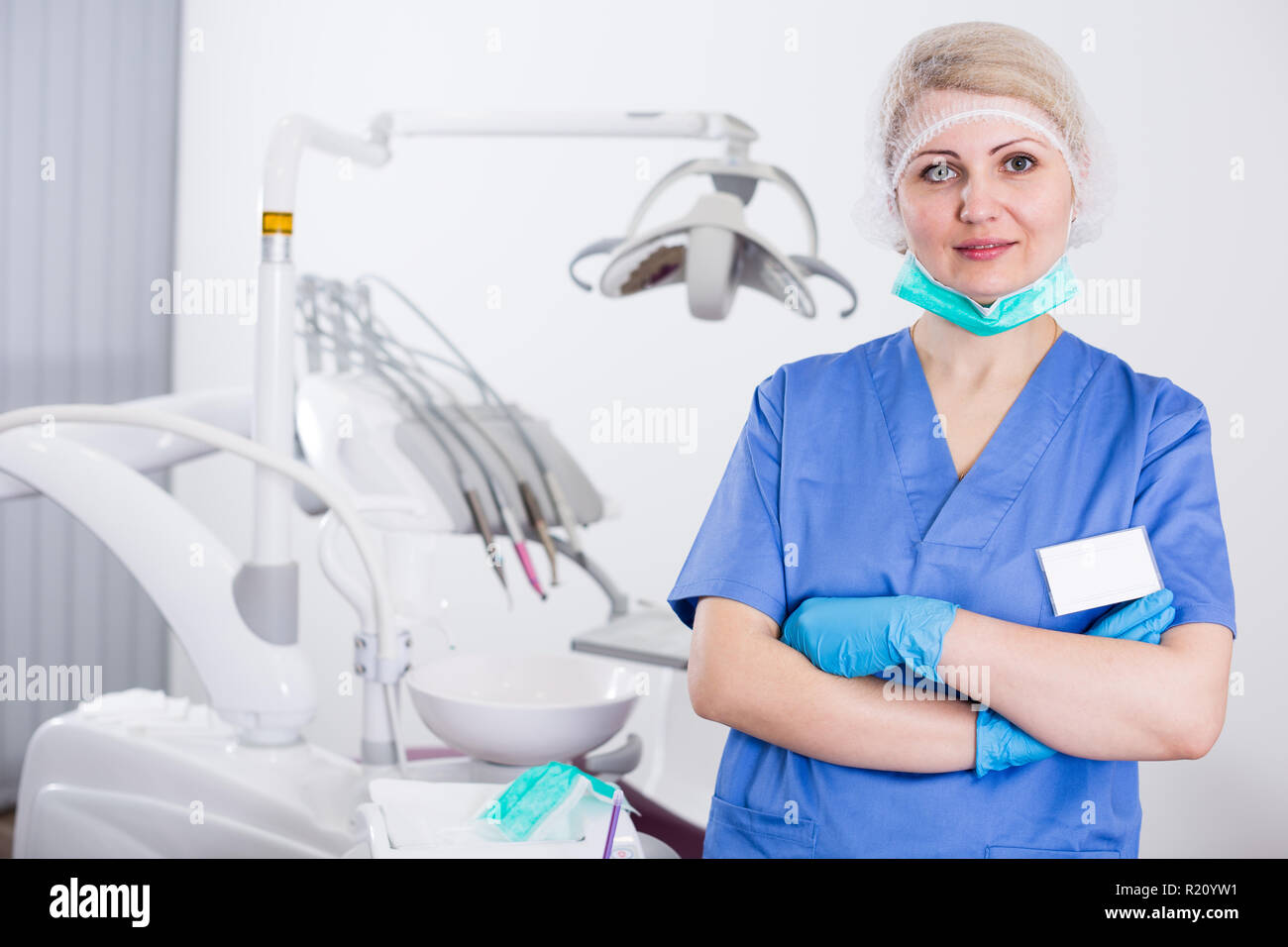 Portrait of professional woman dentist posing with arms crossed at ...