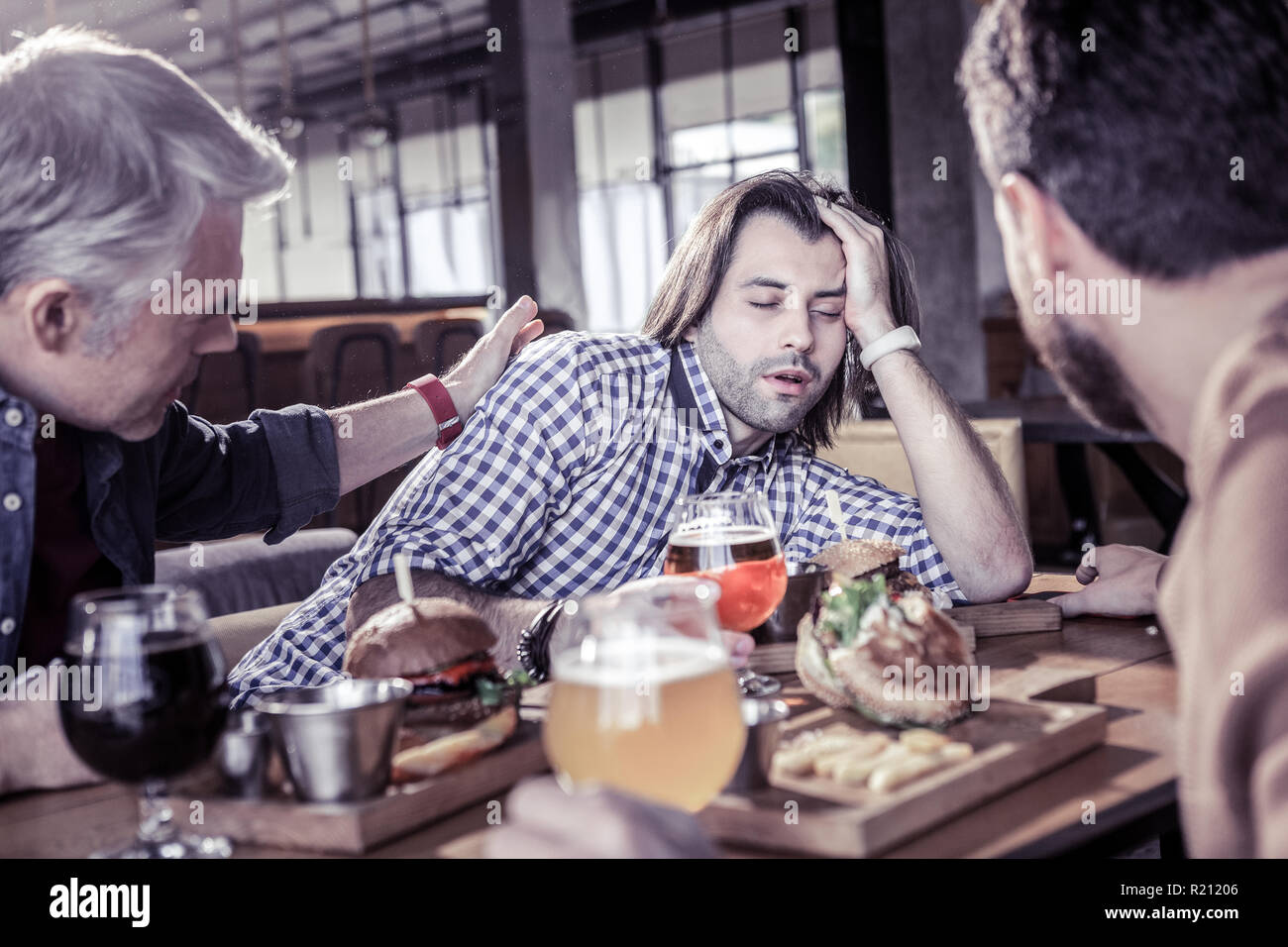 Drunk young man leaning on his arm Stock Photo - Alamy