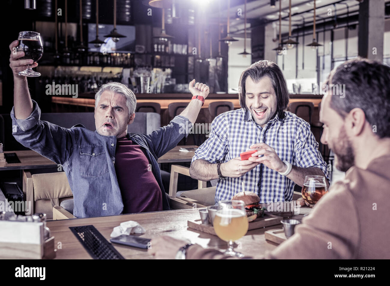 Positive delighted brunette man reading good news Stock Photo - Alamy