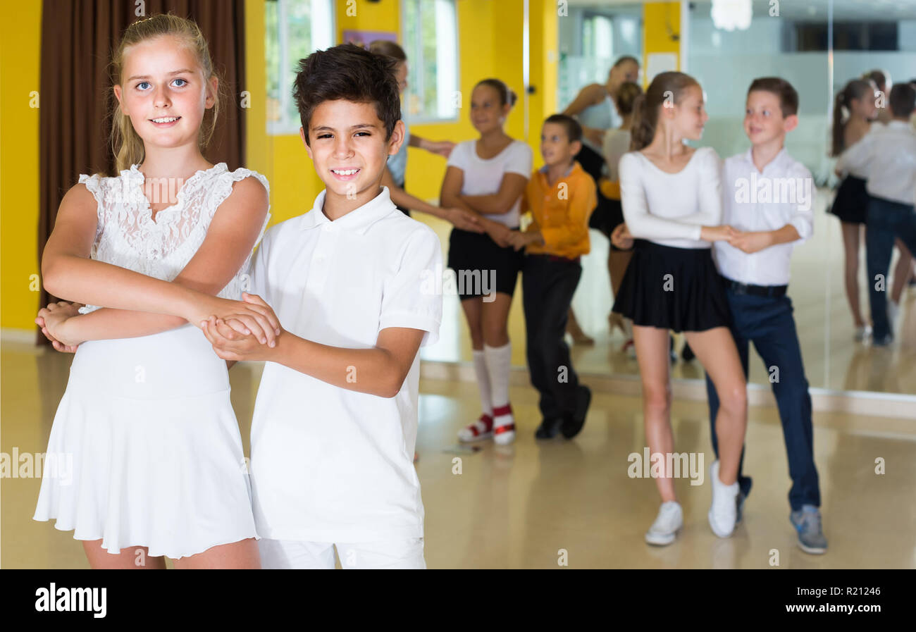 Group of positive smiling spanish children dancing salsa in school ...
