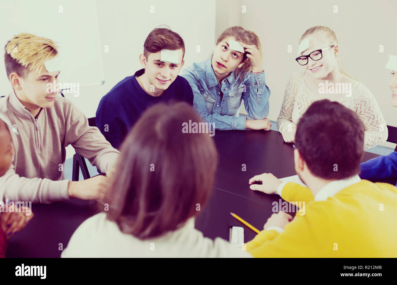 positive european classmates having round of guess-who game during ...