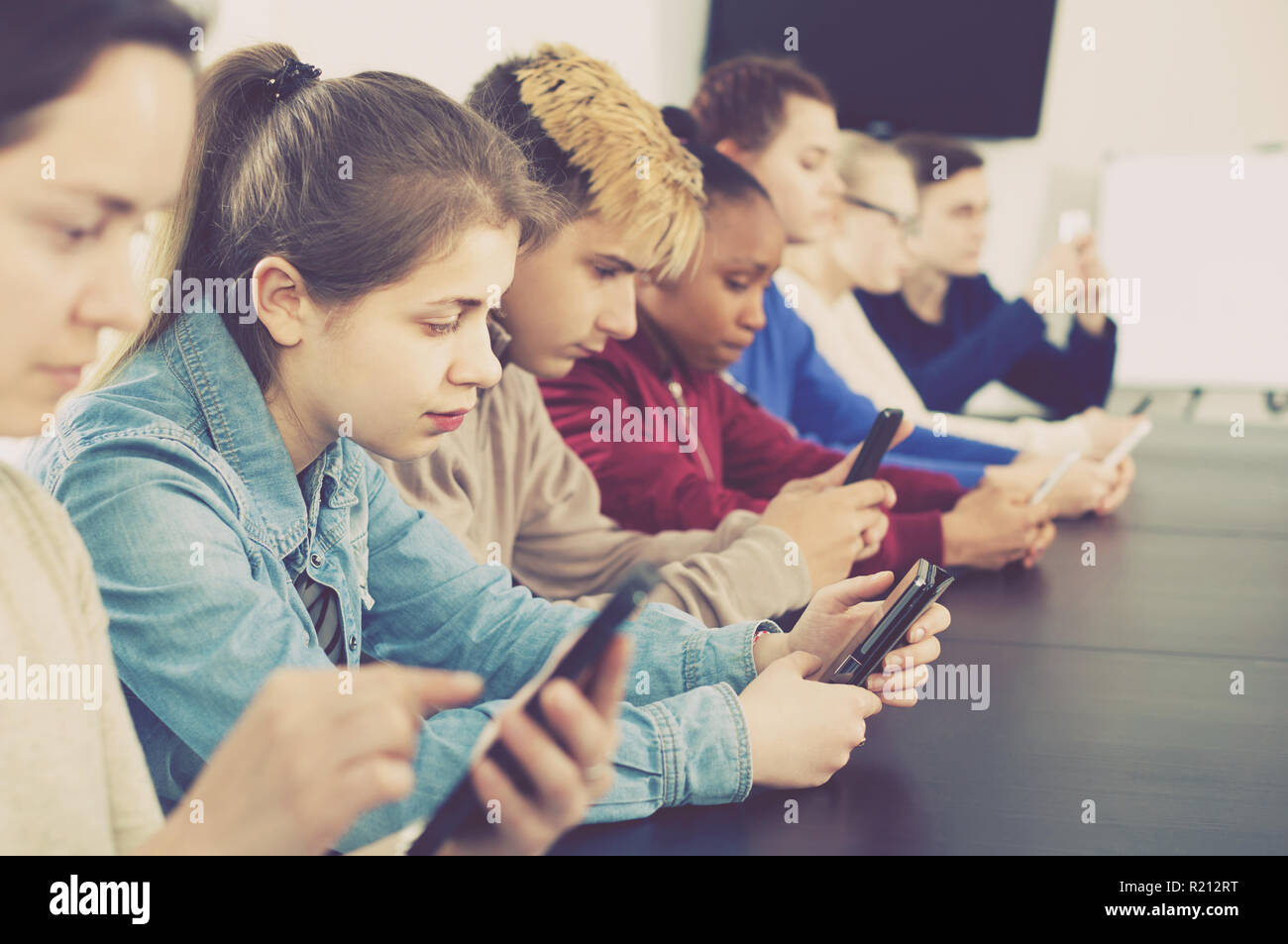 positive russian classmates using their smartphones heavily during ...