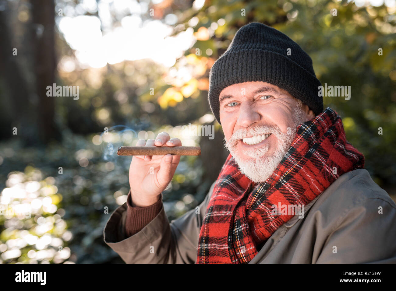 Joyful happy man holding a big cigar Stock Photo - Alamy