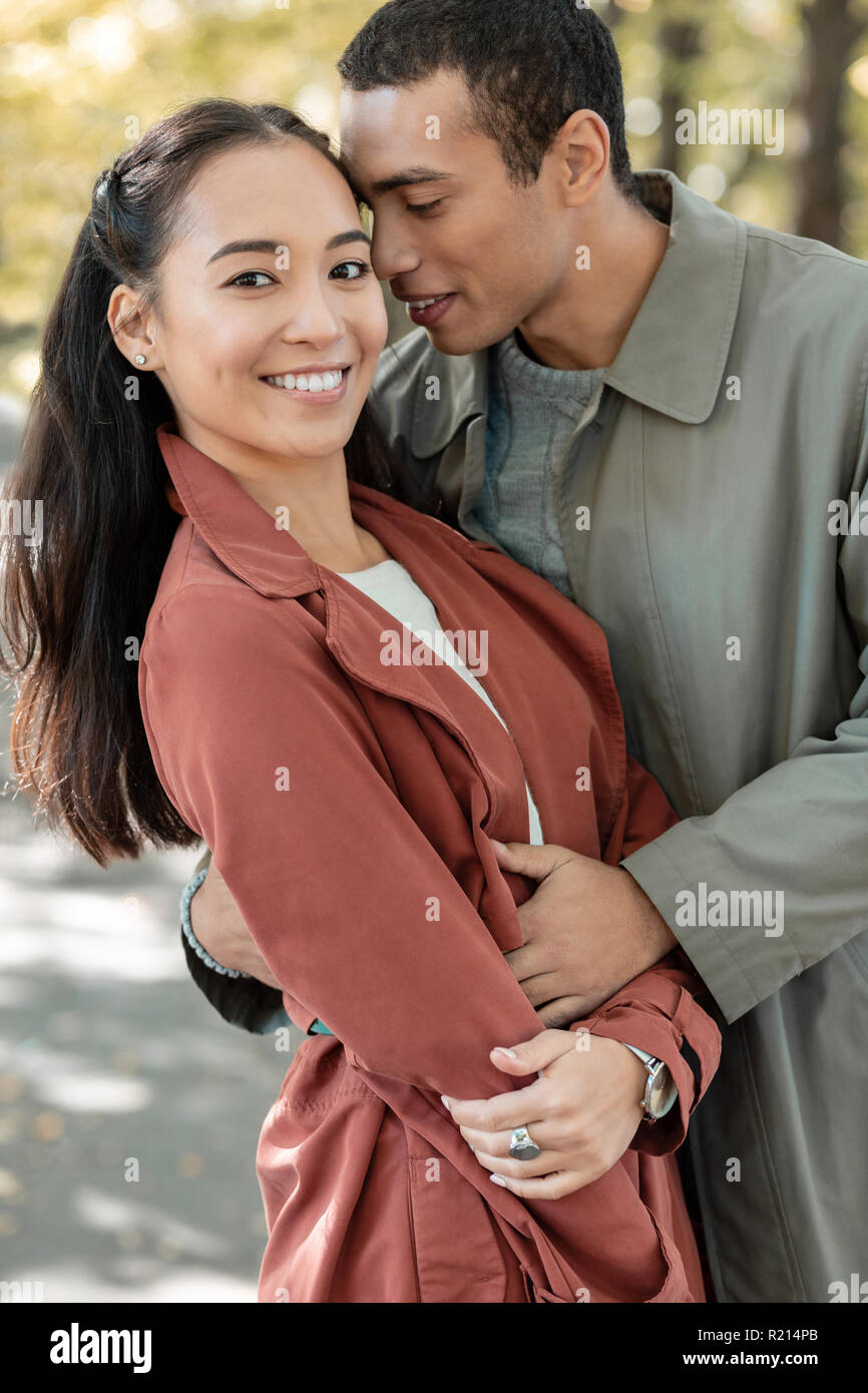 Cheerful Asian girl standing close to her friend Stock Photo - Alamy